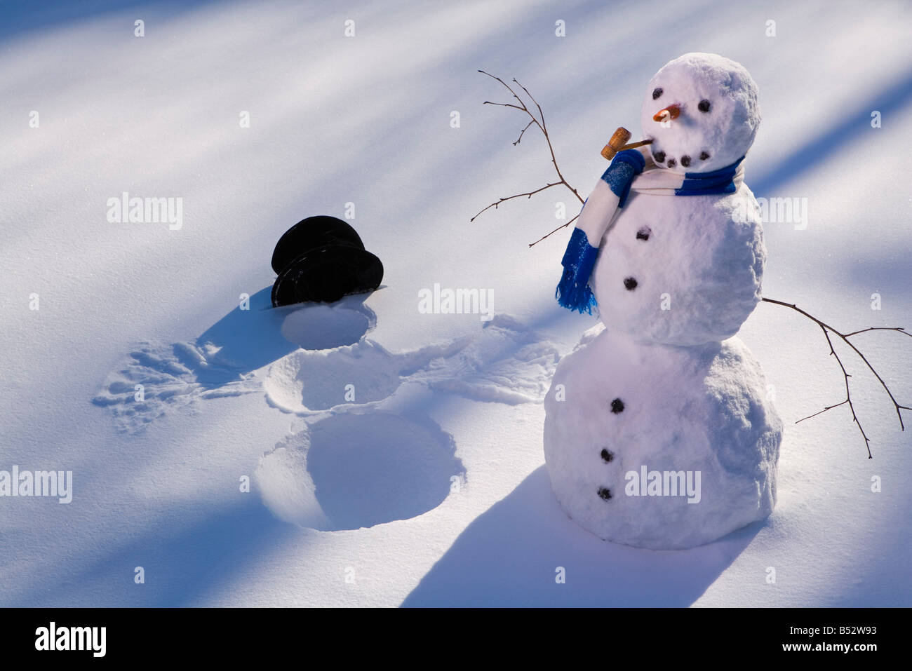 Snowman in forest making snow angel imprint in snow in late afternoon ...
