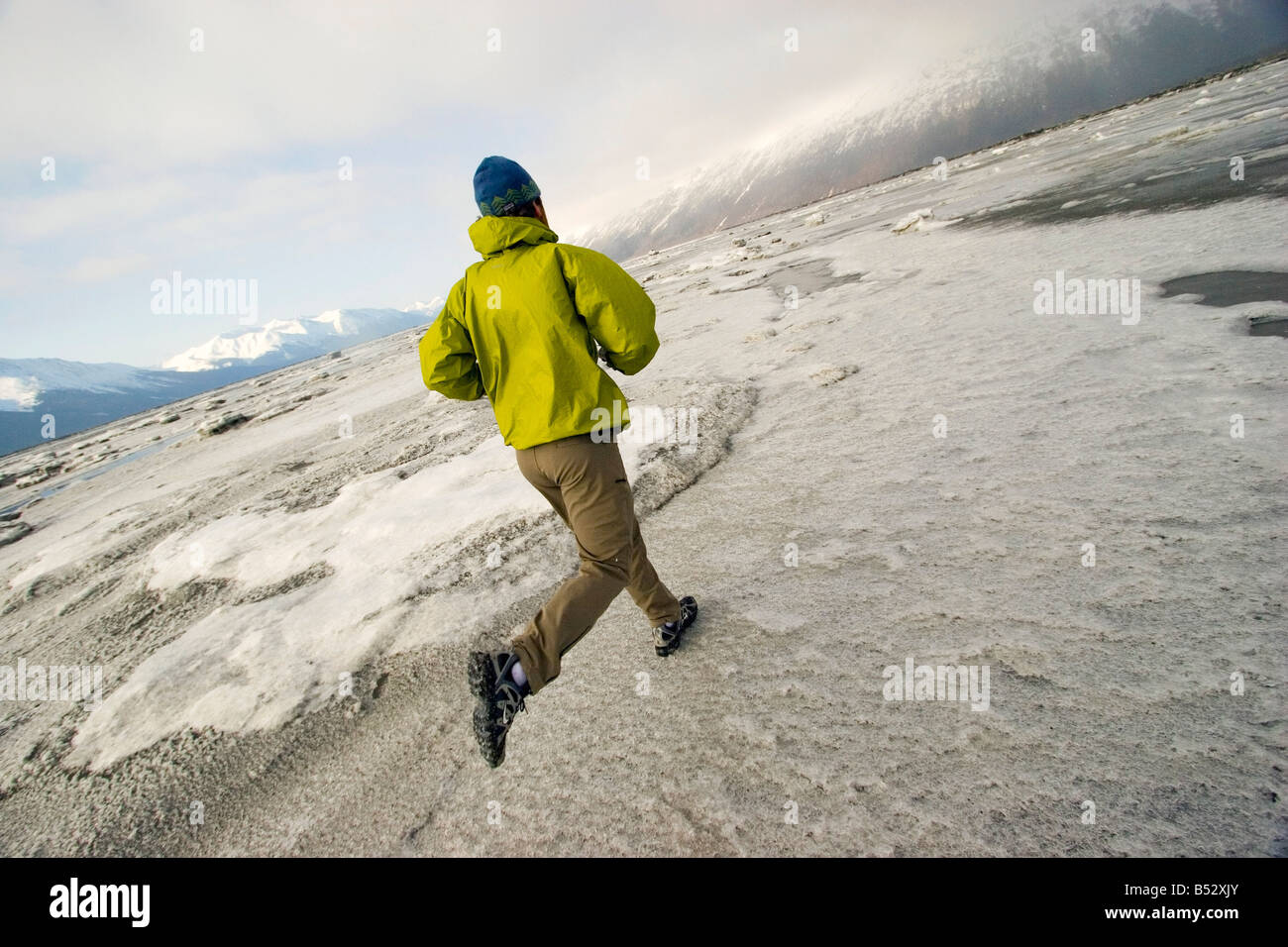 Man runs along Turnagain Arm on crumbly ice slush and mud surface in ...