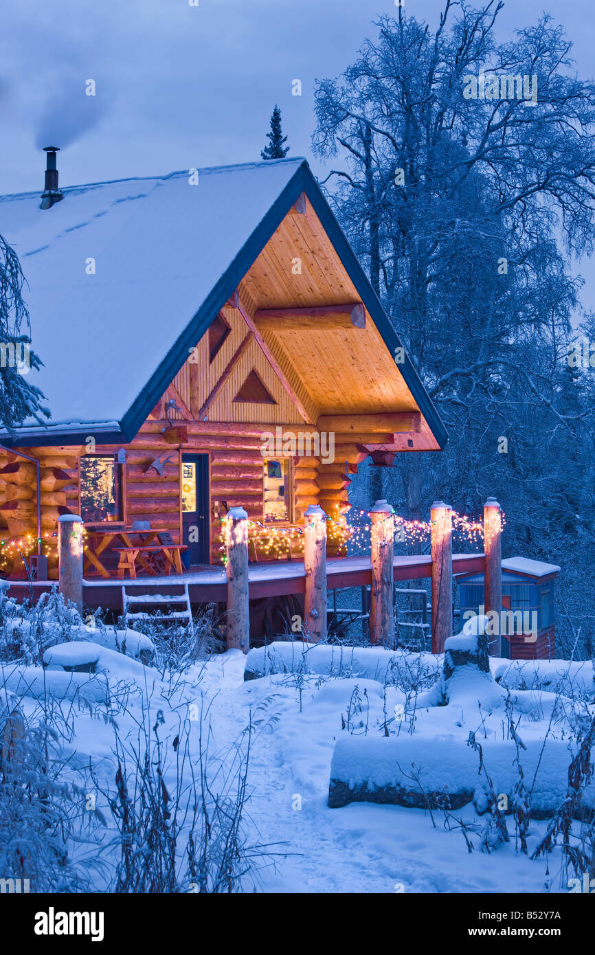 Log Cabin in the woods decorated with Christmas lights at twilight near ...