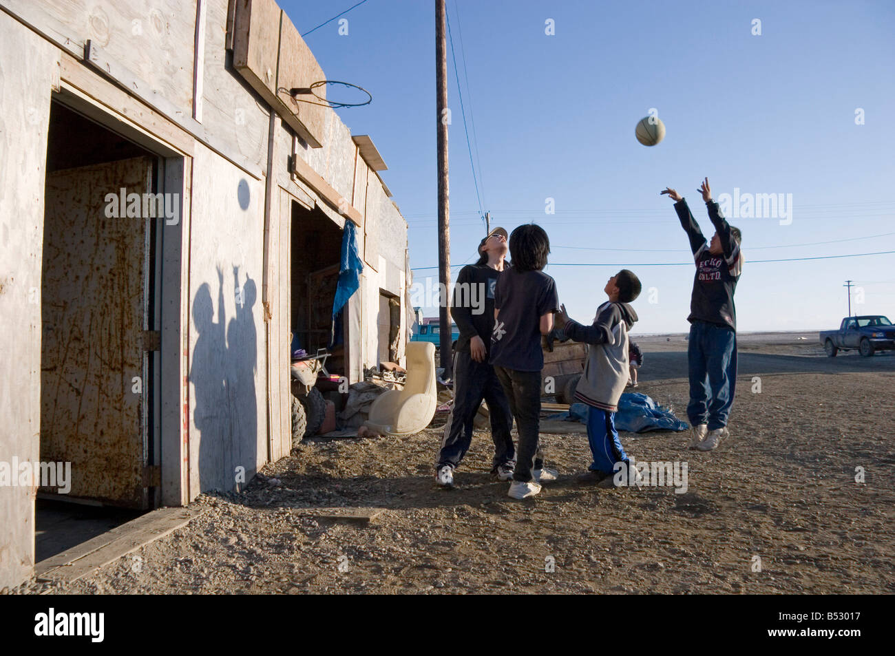 Native boys playing basketball outside in late summer sun Kaktovik ...