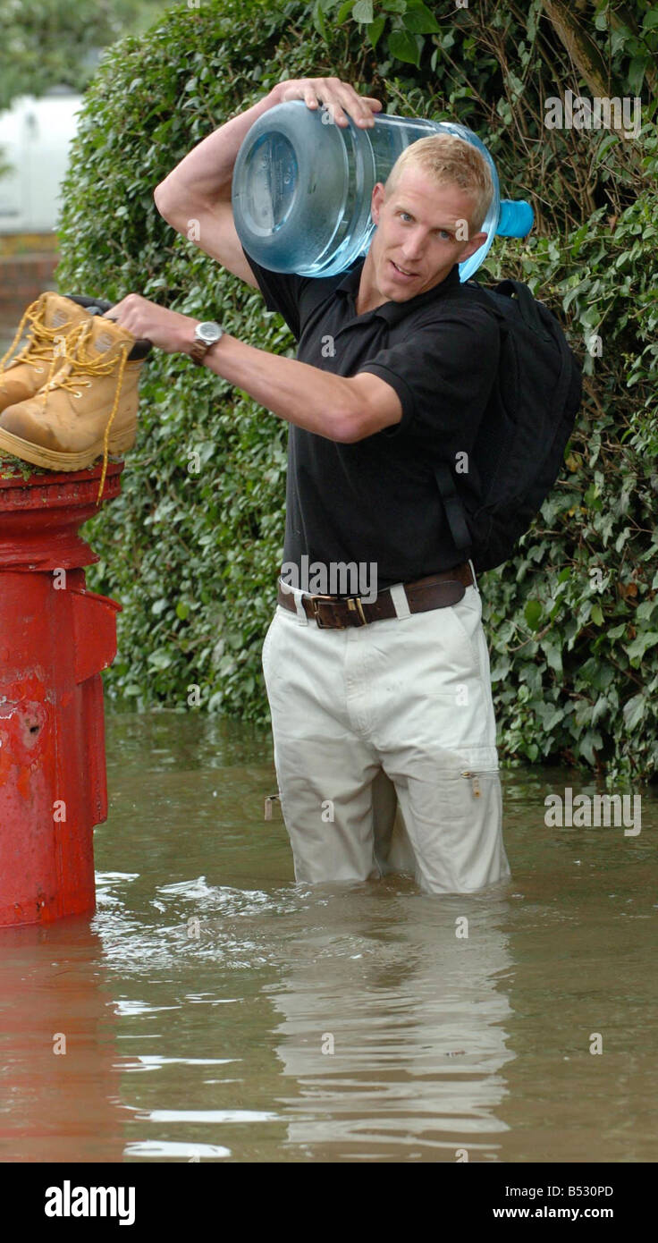 Man collects fresh drinking water from an area damaged by flood in ...