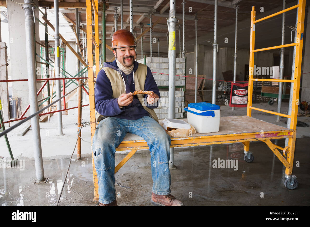 Mixed race construction worker eating lunch Stock Photo - Alamy