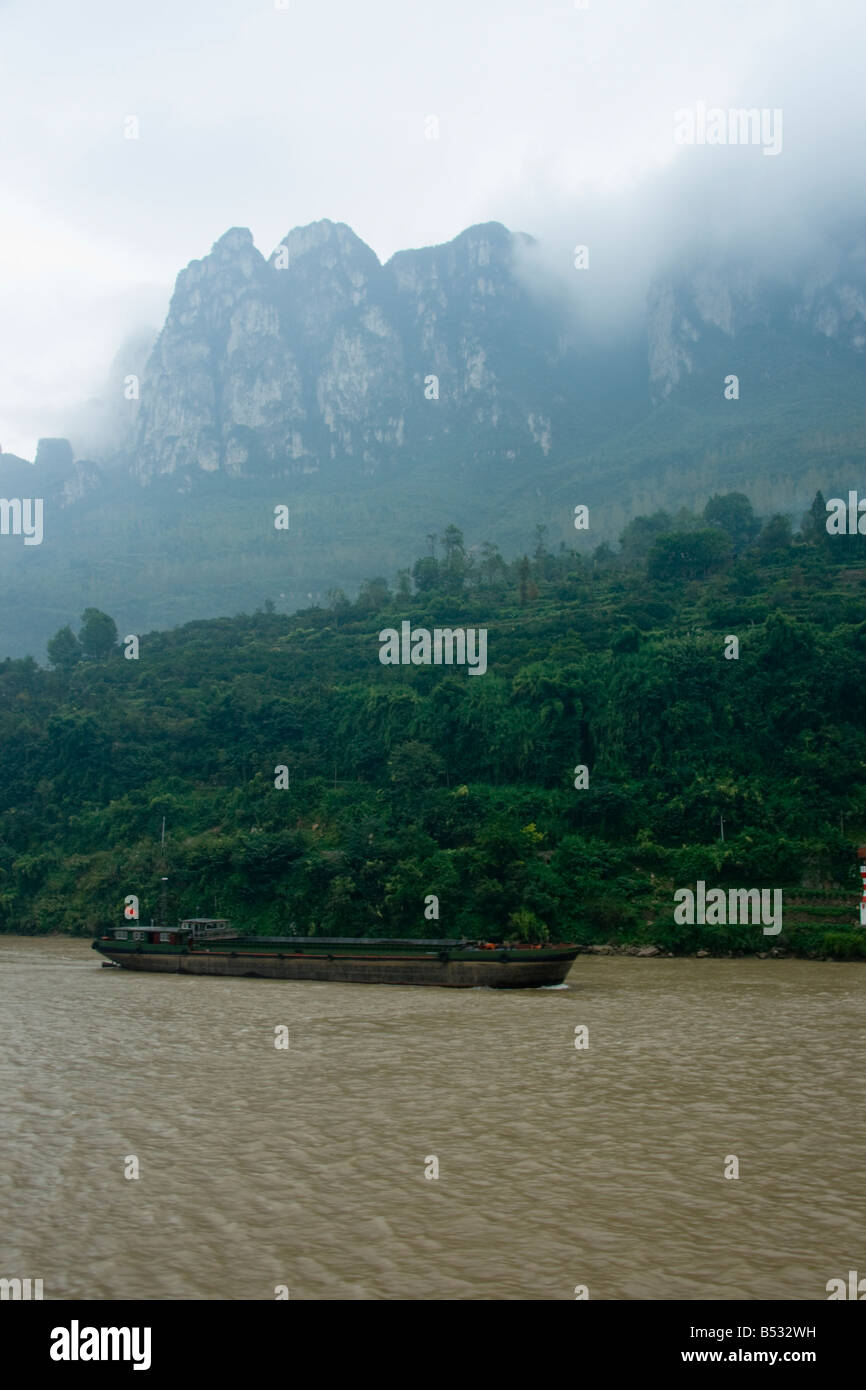 A Chinese barge or cargo ship on the Yangtze River, China with hills ...