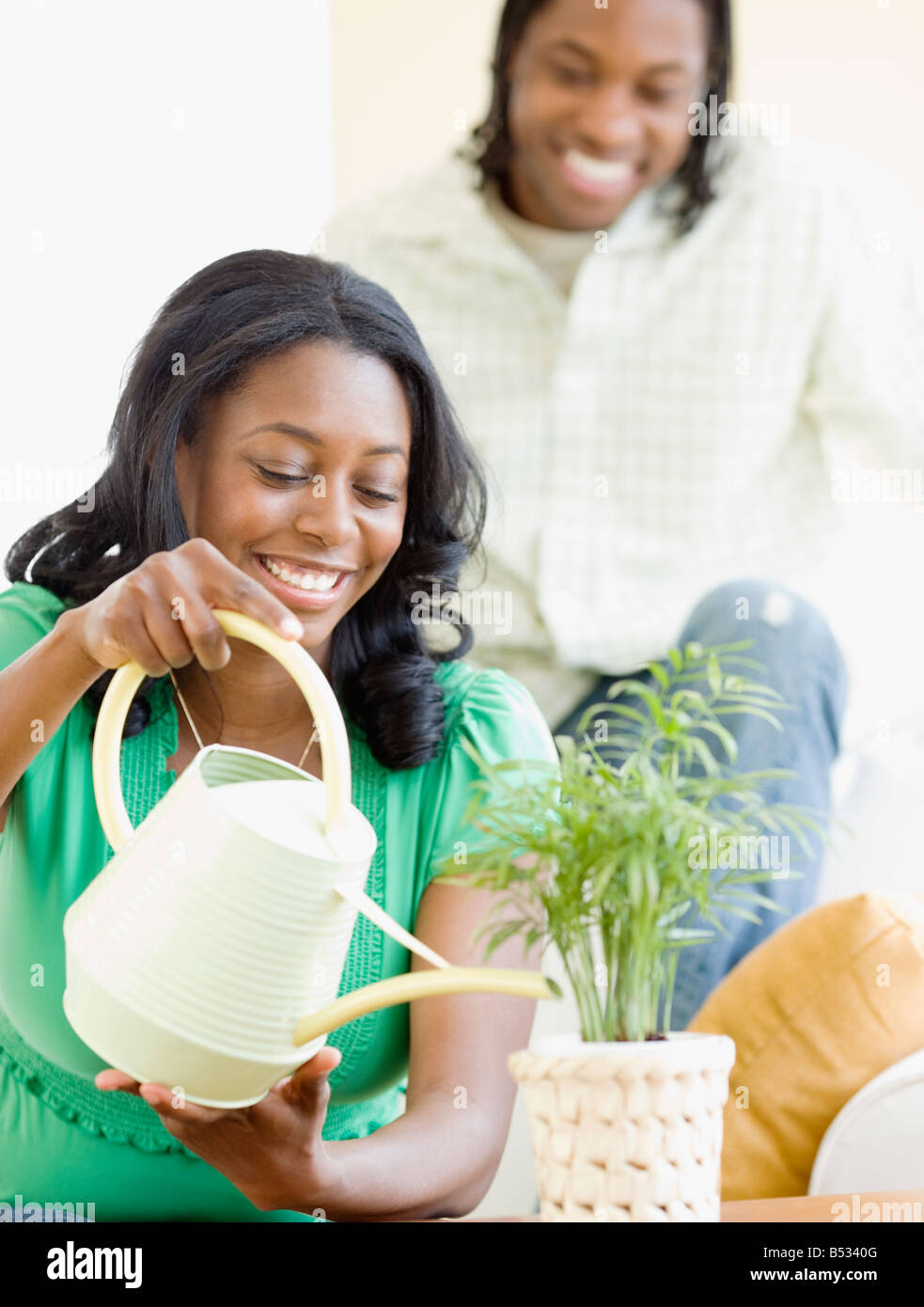 African couple watering plant Stock Photo - Alamy