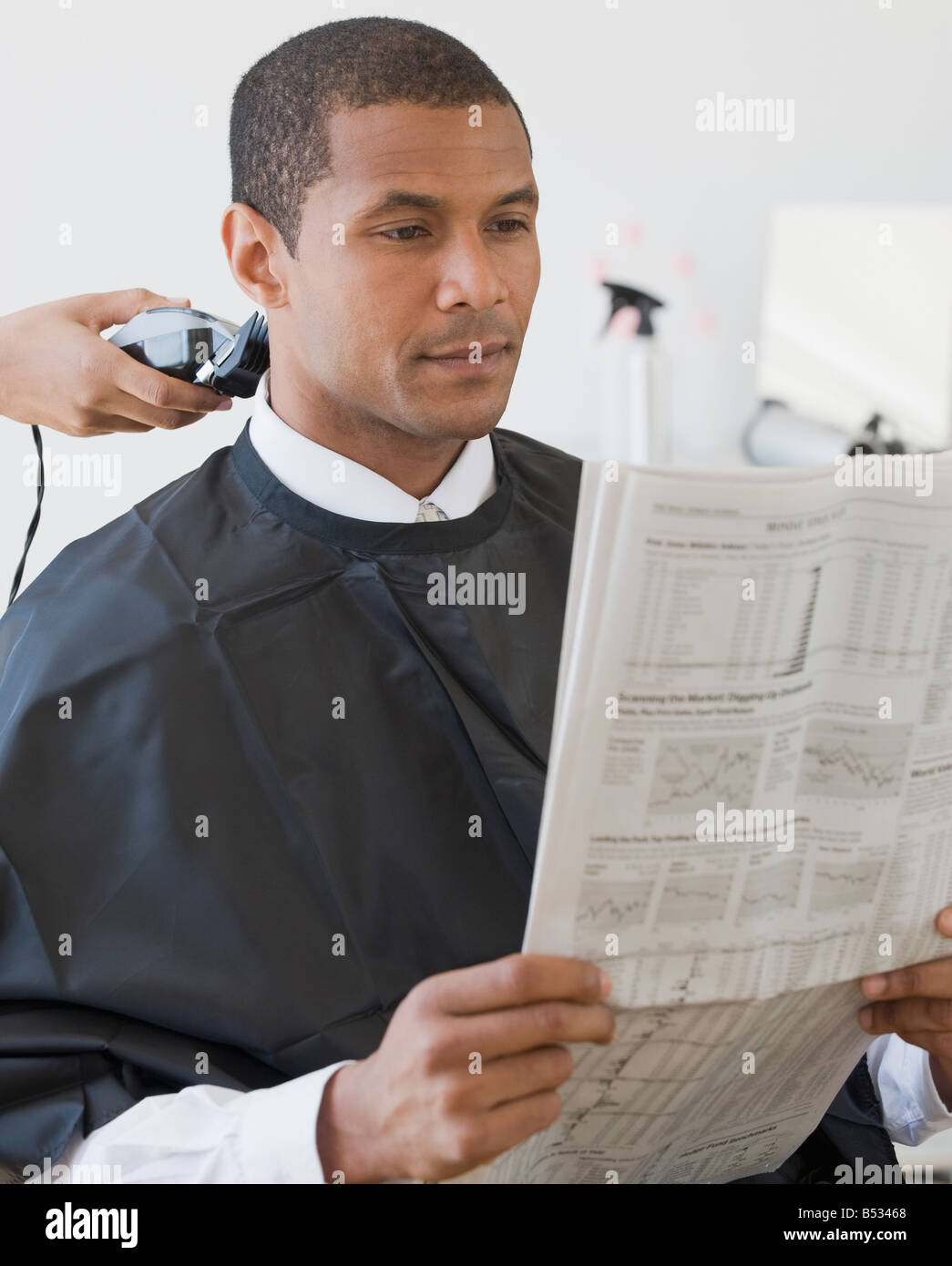 African man reading paper at barbershop Stock Photo - Alamy