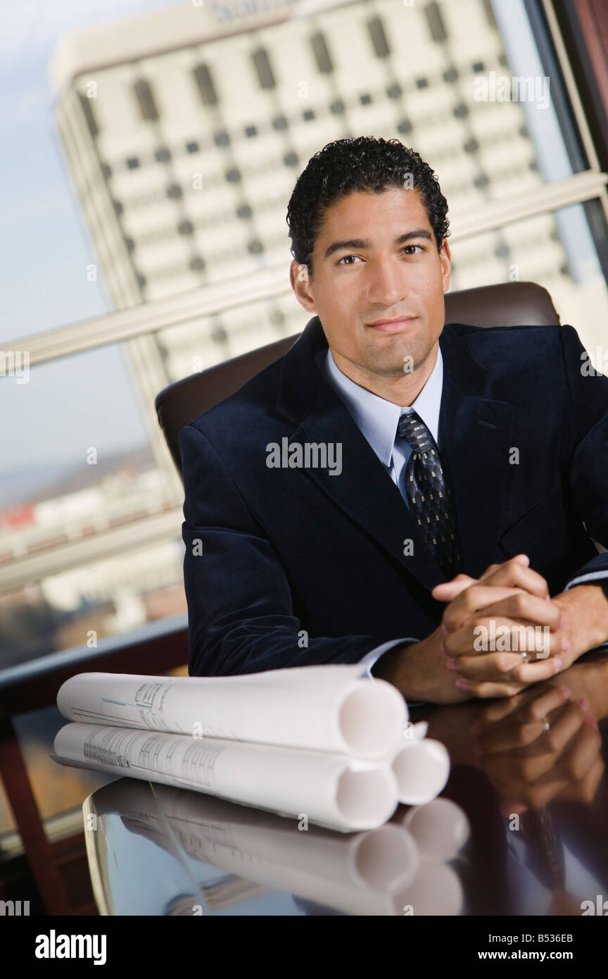 Mixed race businessman with blueprints Stock Photo - Alamy