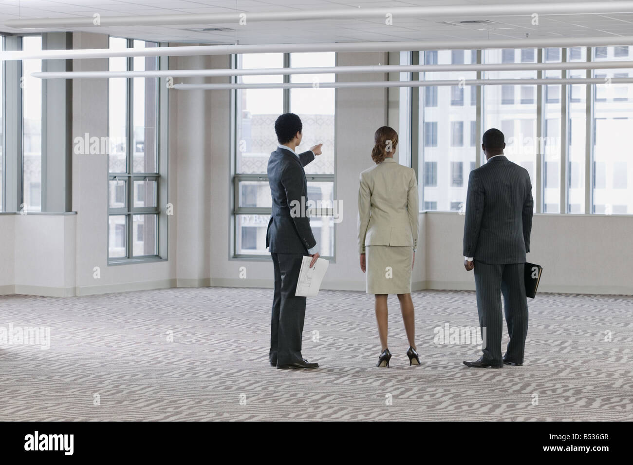 Multi-ethnic business people viewing empty building Stock Photo - Alamy