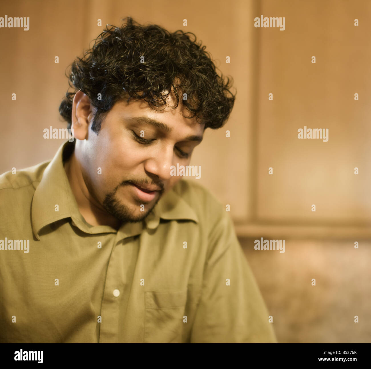 Indian man with goatee looking down Stock Photo - Alamy