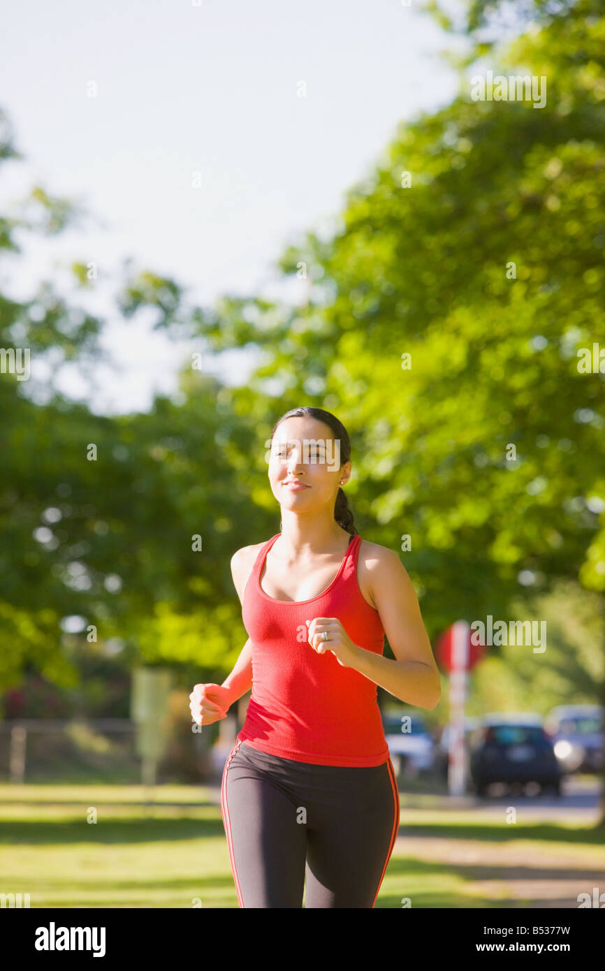 Hispanic woman jogging in park Stock Photo - Alamy