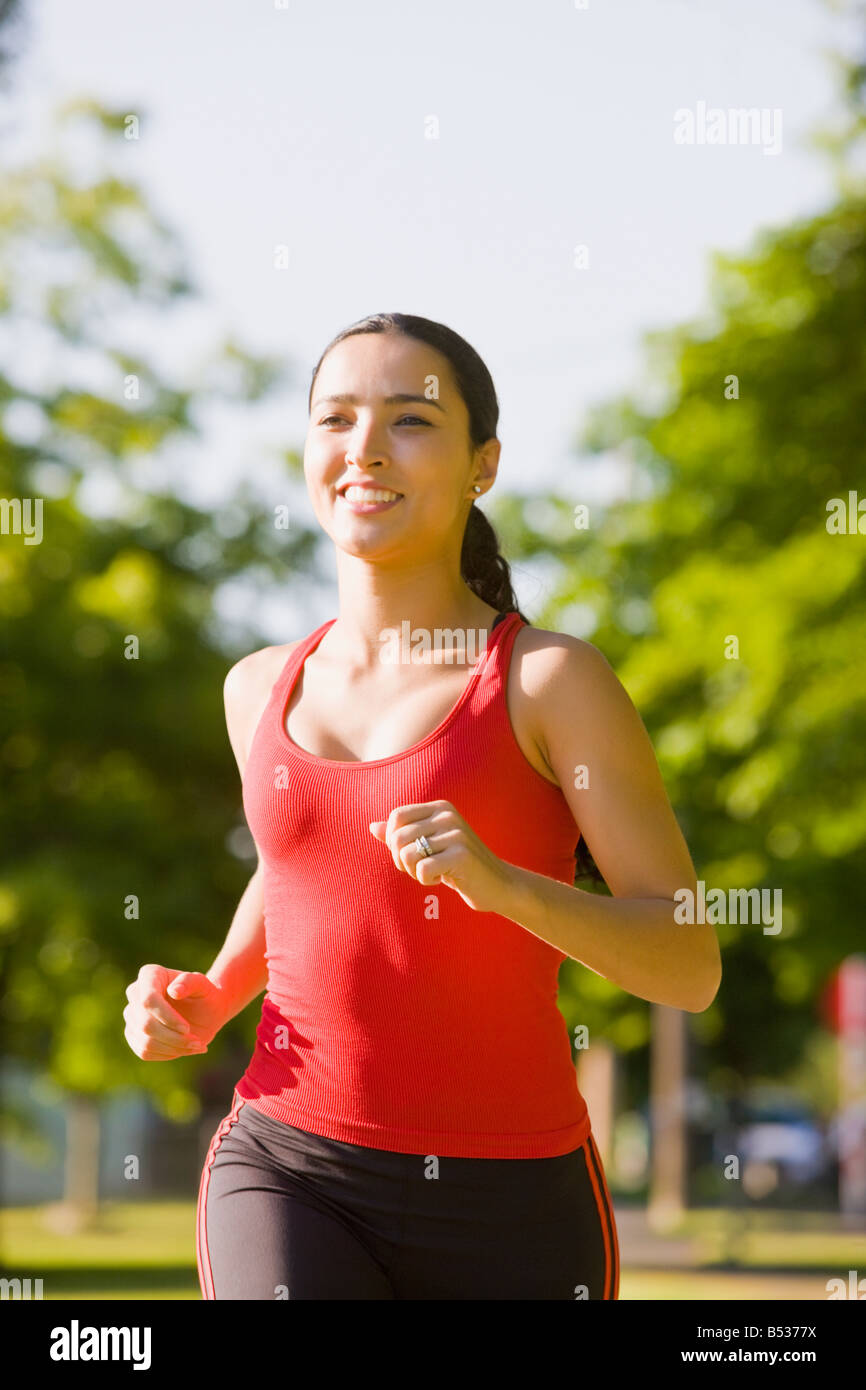 Hispanic woman jogging in park Stock Photo - Alamy