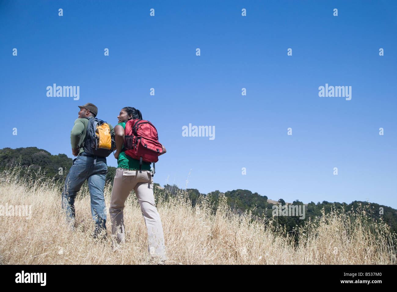 Multi-ethnic couple backpacking in rural area Stock Photo - Alamy
