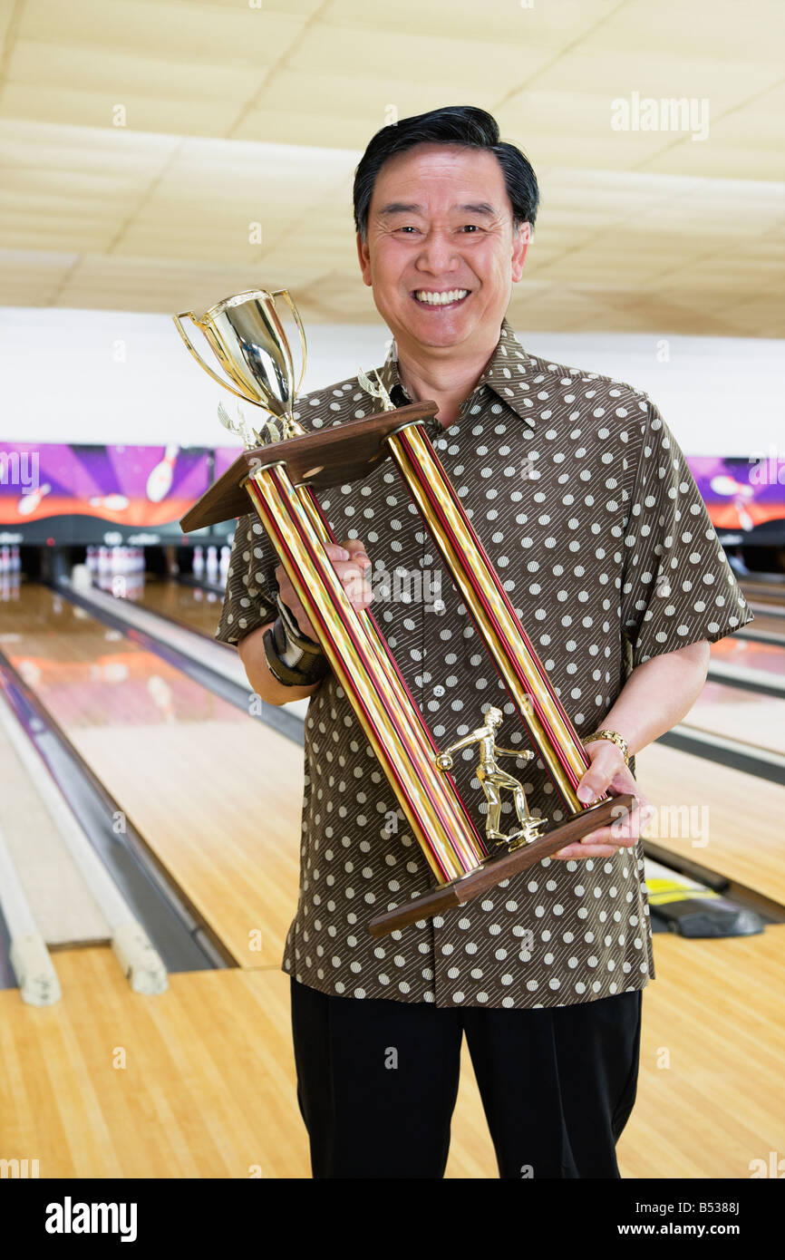Asian man with bowling trophy Stock Photo - Alamy