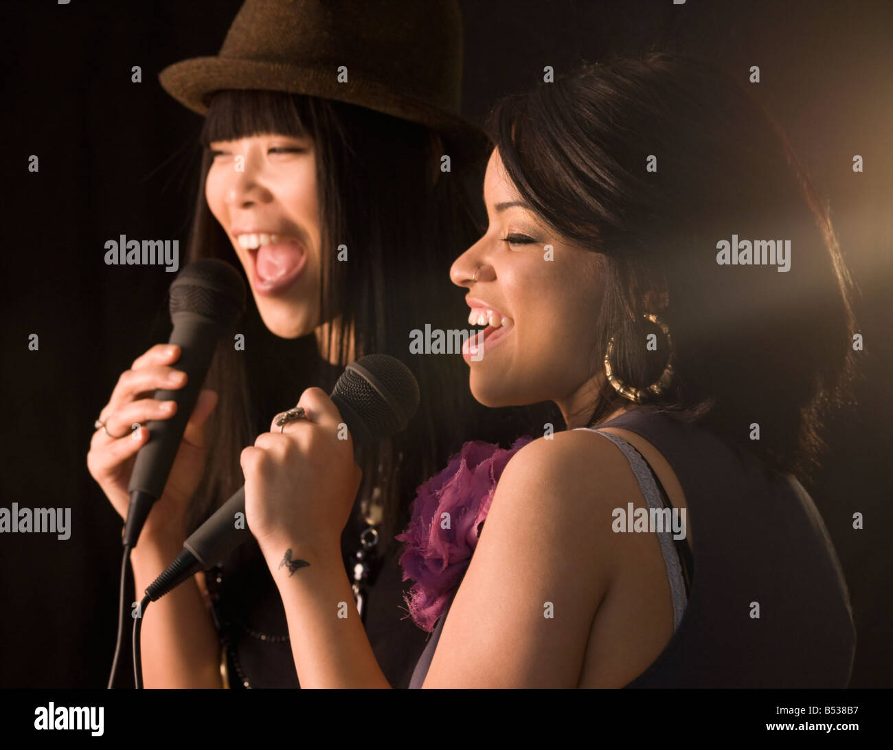 Multi-ethnic friends singing karaoke Stock Photo - Alamy