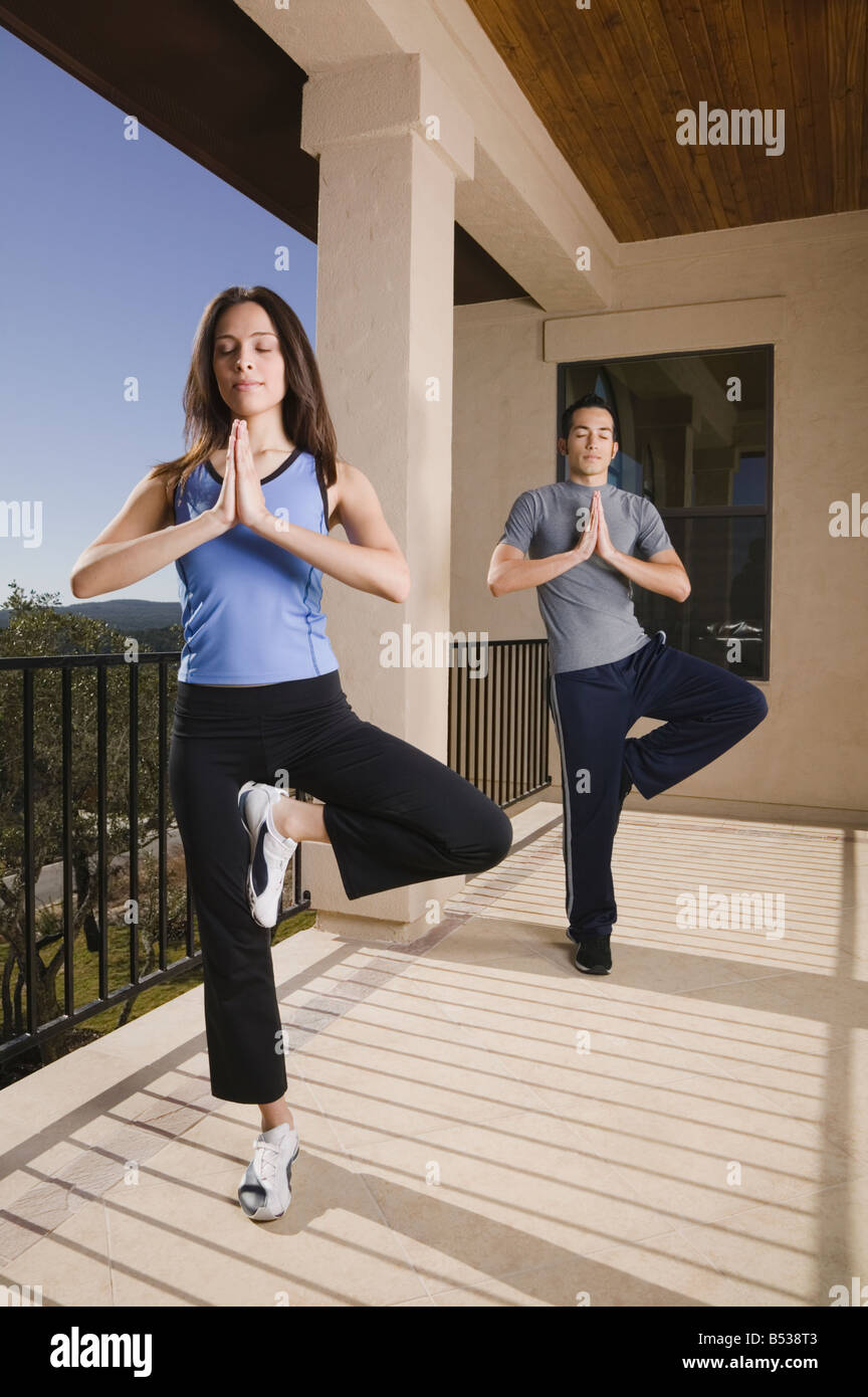 Hispanic couple doing yoga on balcony Stock Photo - Alamy