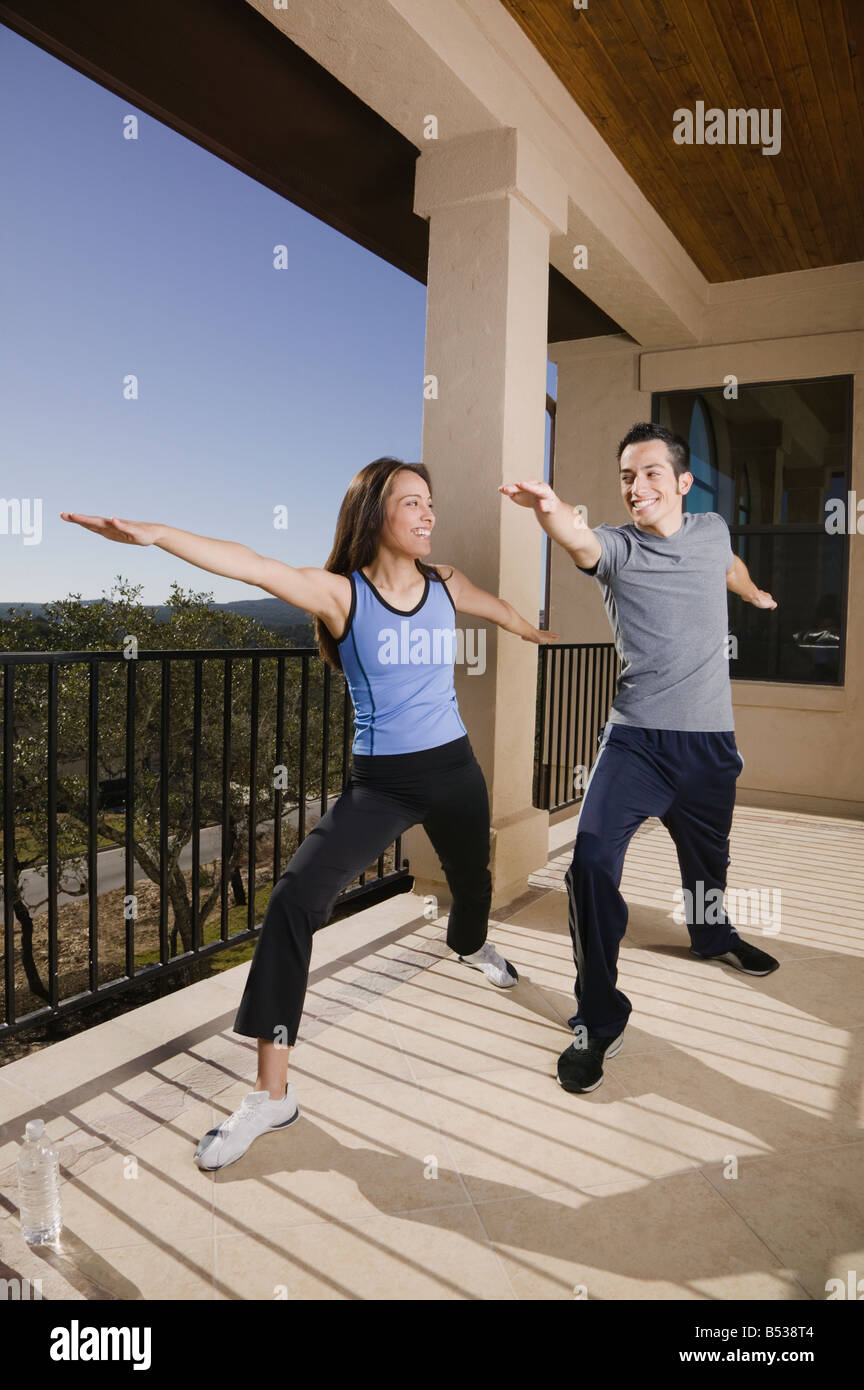 Hispanic couple doing yoga on balcony Stock Photo - Alamy