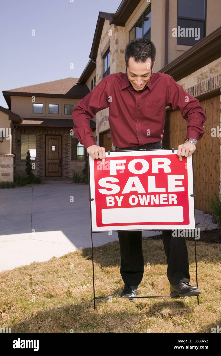 Hispanic man placing for sale sign in yard Stock Photo - Alamy