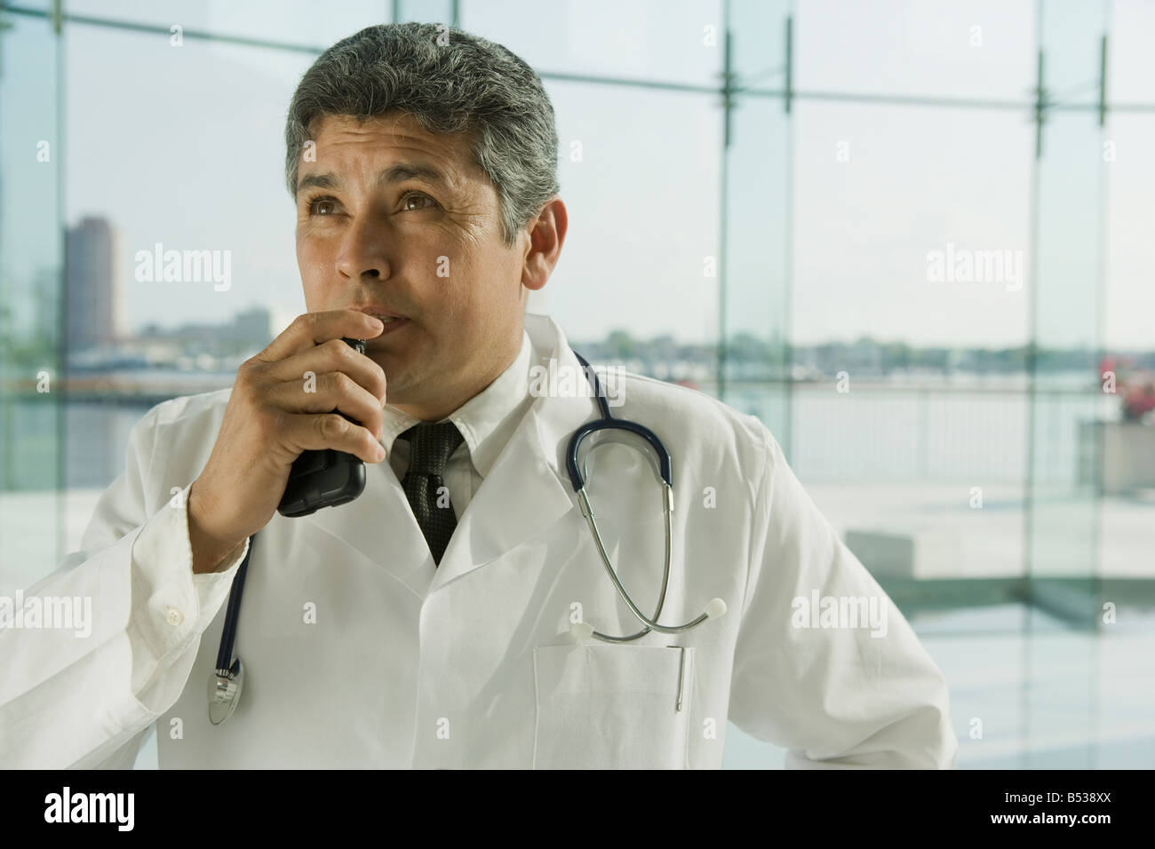 Hispanic doctor in lab coat speaking into dictaphone Stock Photo - Alamy