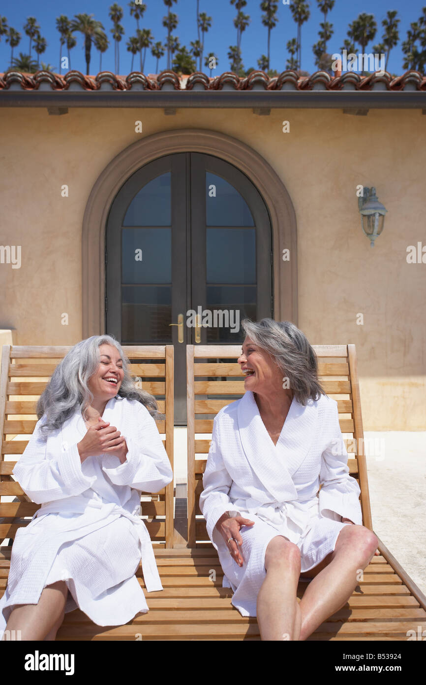 Friends laying on lounge chairs at resort Stock Photo - Alamy