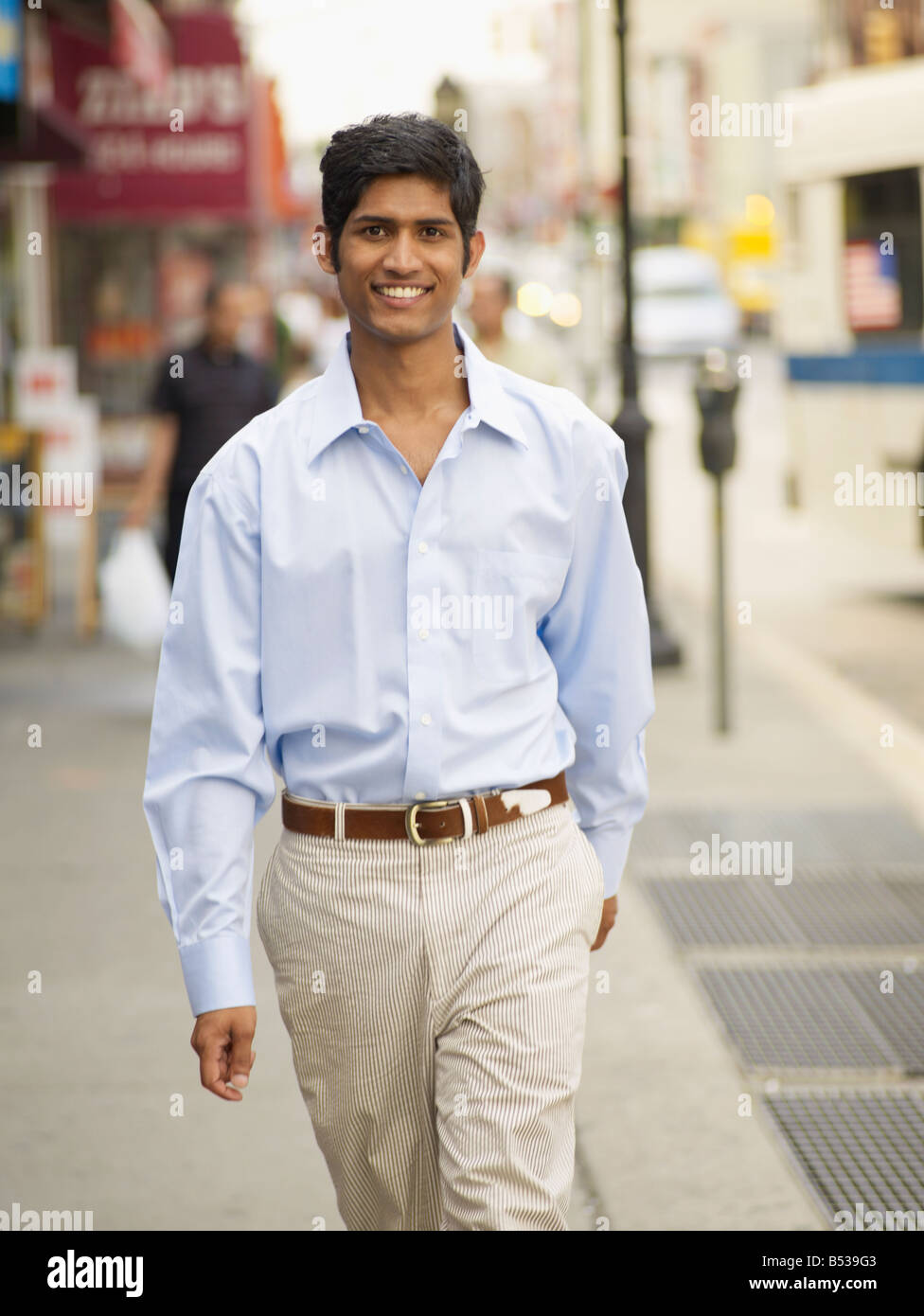 Indian man walking in urban setting Stock Photo - Alamy