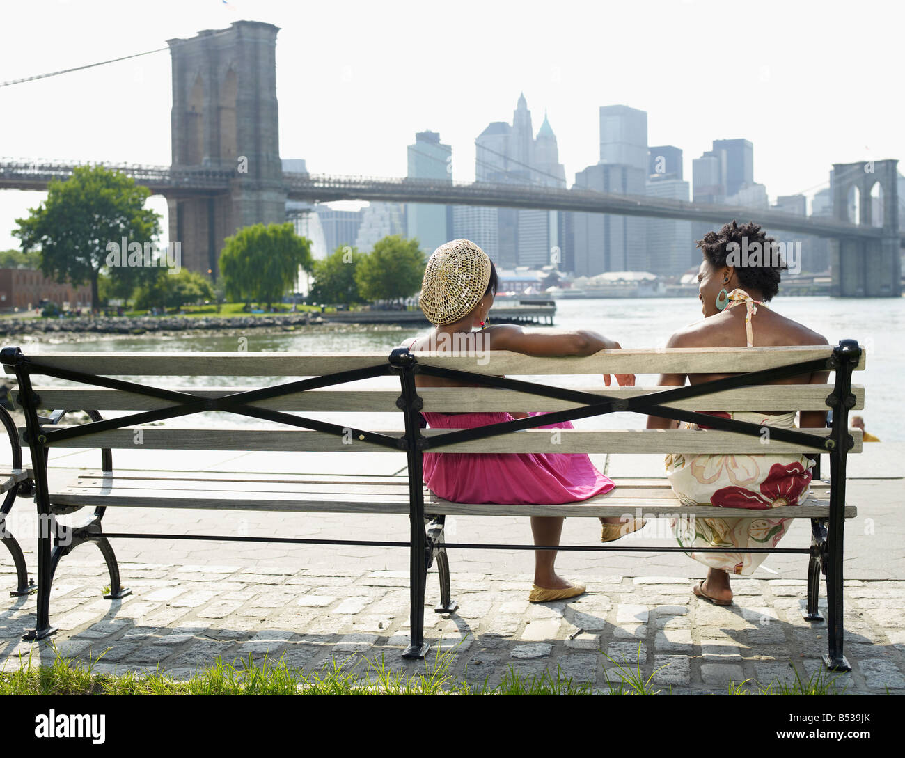 African women sitting on bench at urban waterfront Stock Photo - Alamy