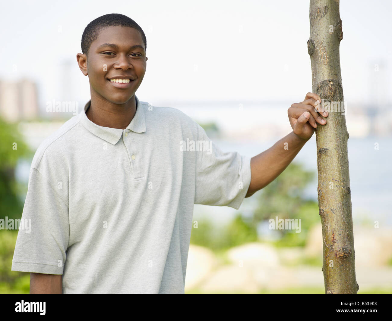 Young man leaning tree trunk park hi-res stock photography and images ...