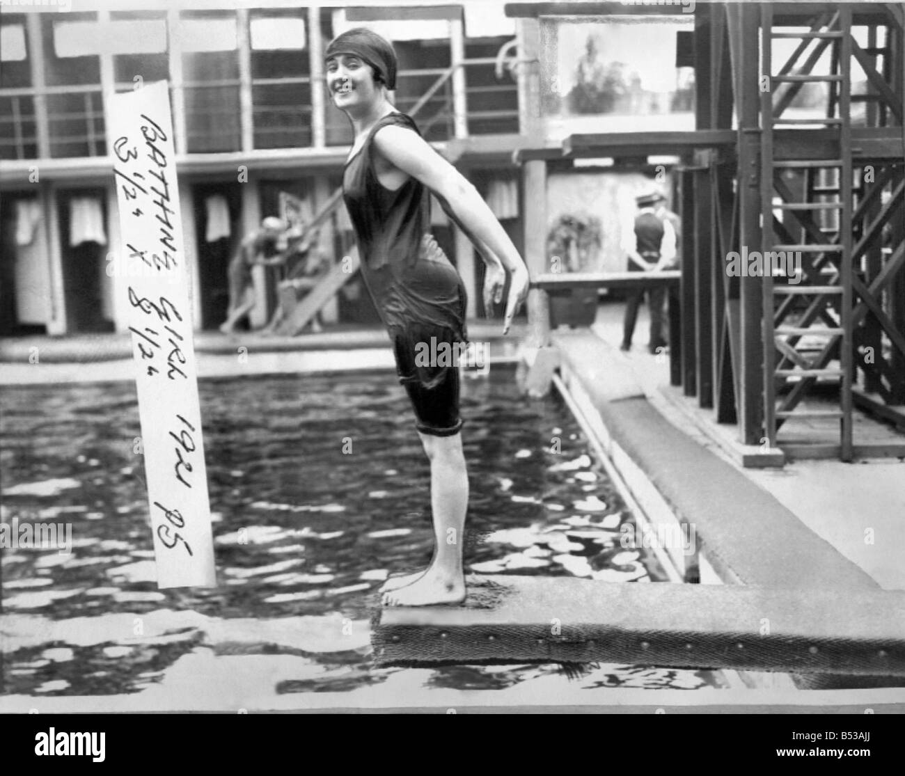 Woman in a 1920's style swimming costume about to dive in to a swimming ...