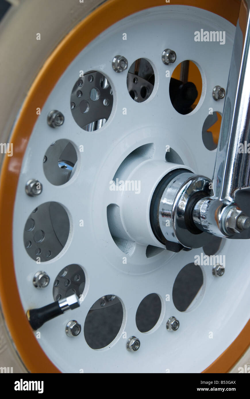 White motorbike wheel with circular holes and orange rim Stock Photo ...