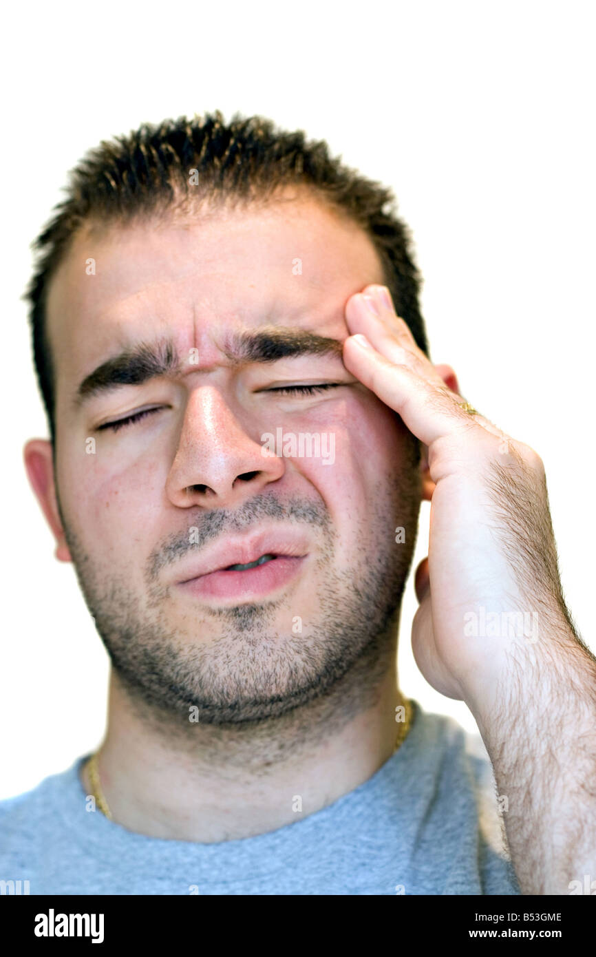 A young man grasps his head in anguish from pain or even stress Stock ...