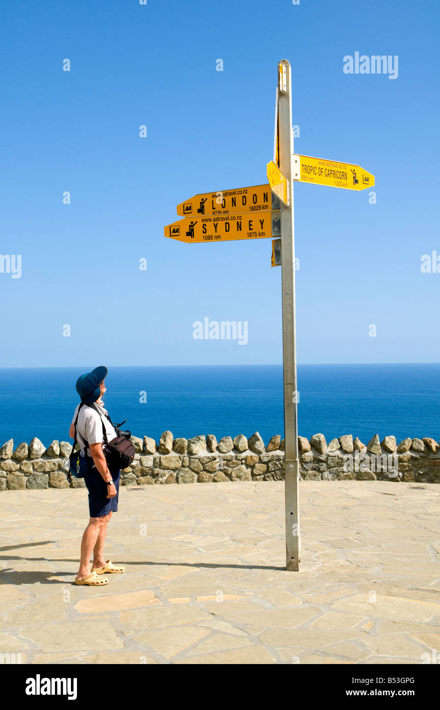 Tourist looking at a signpost at Cape Reinga, Te Rerenga Wairua (The ...