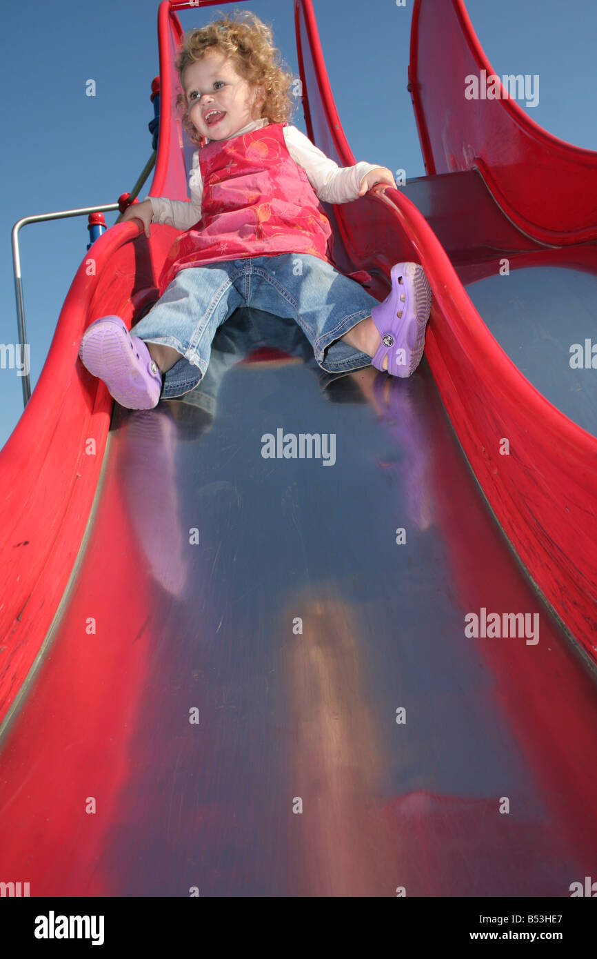 One-year-old girl on playground slide Stock Photo - Alamy