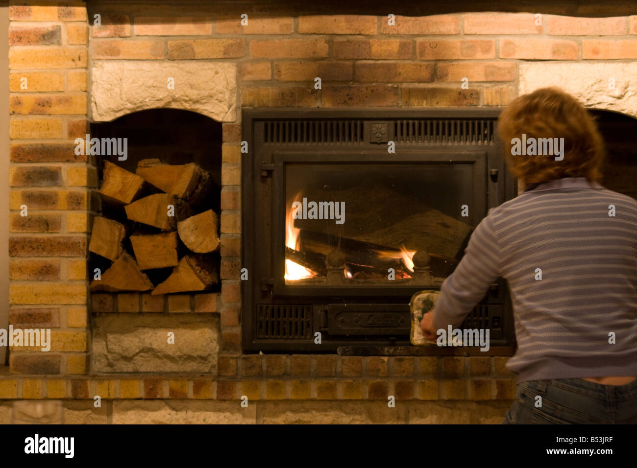 Fireplace adding wood fire hi-res stock photography and images - Alamy