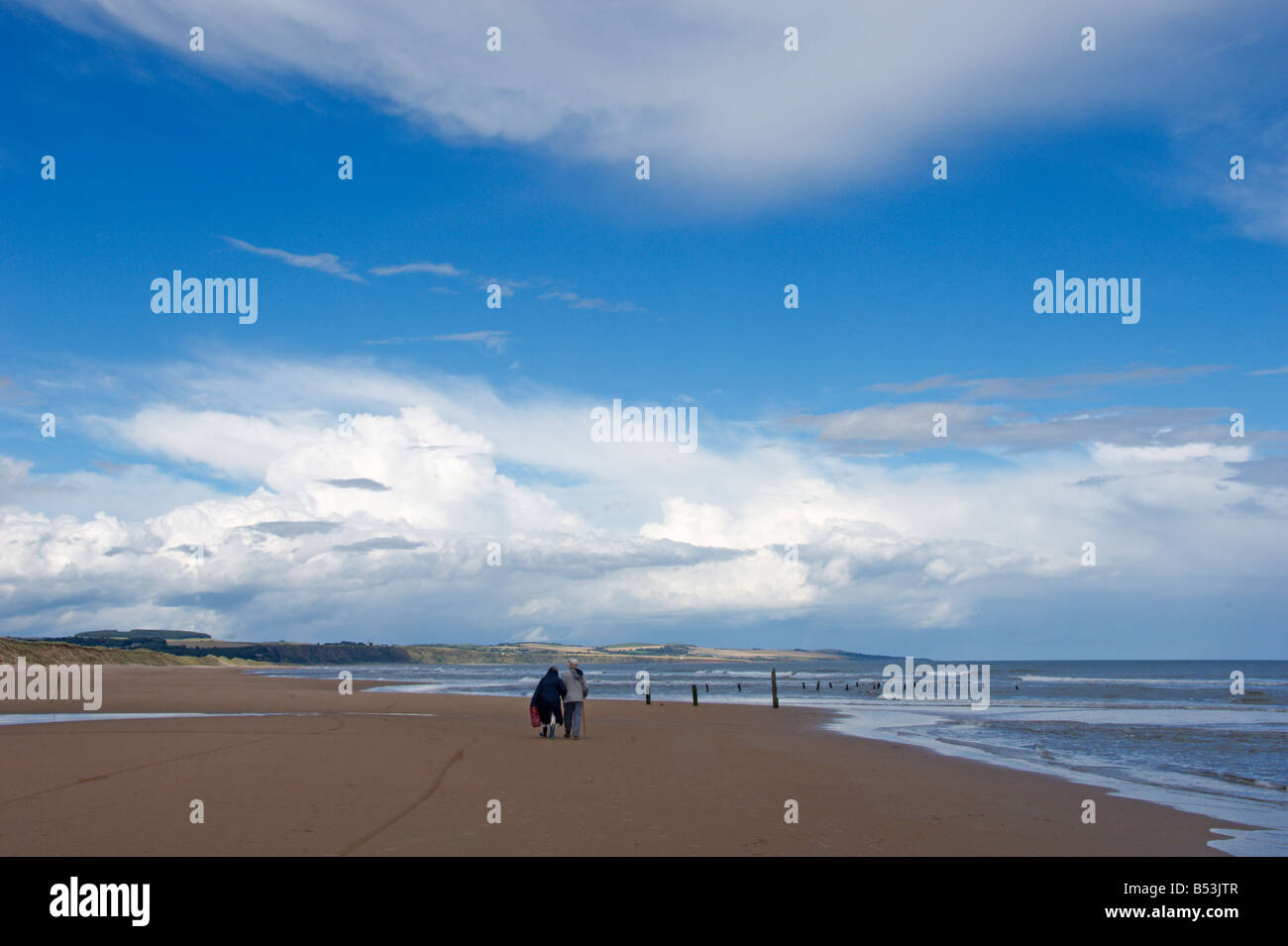 Elderly couple walking along Montrose beach skyscape looking north to ...