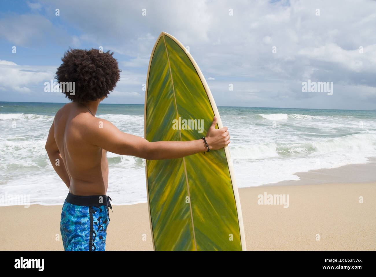 African man at beach with surfboard Stock Photo - Alamy
