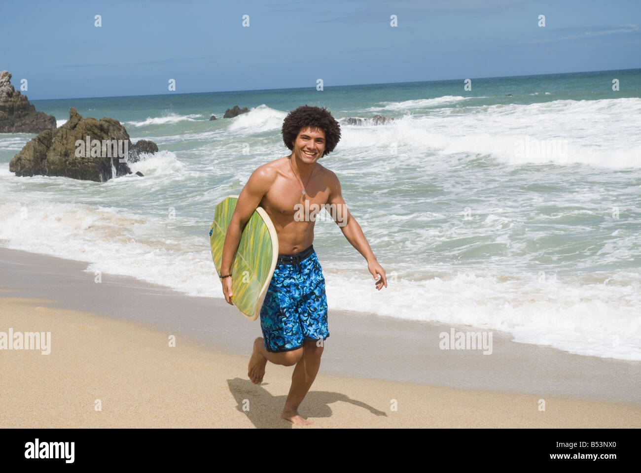 African man at beach with surfboard Stock Photo - Alamy