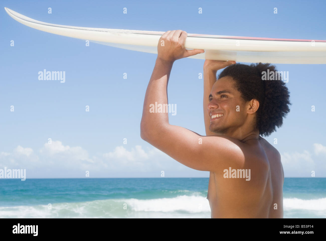 African man carrying surfboard at beach Stock Photo - Alamy