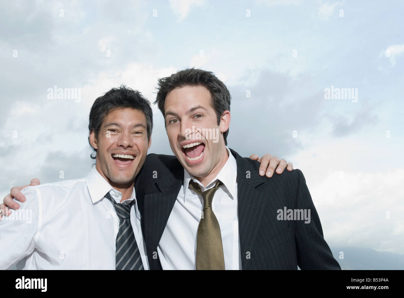 Hispanic businessmen hugging Stock Photo - Alamy