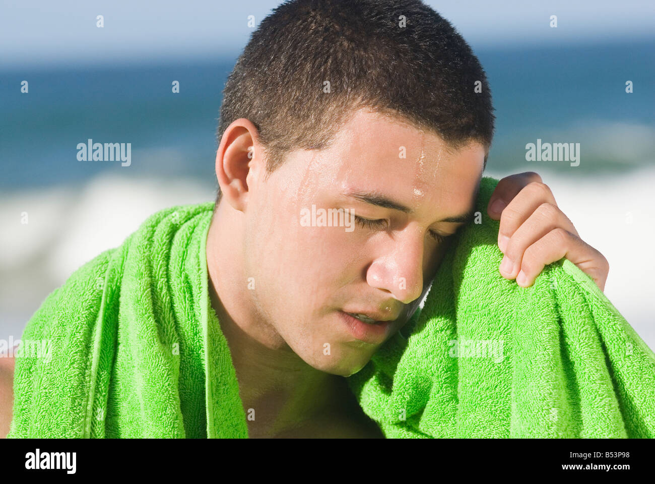 Sweating Hispanic man wiping face with towel Stock Photo - Alamy
