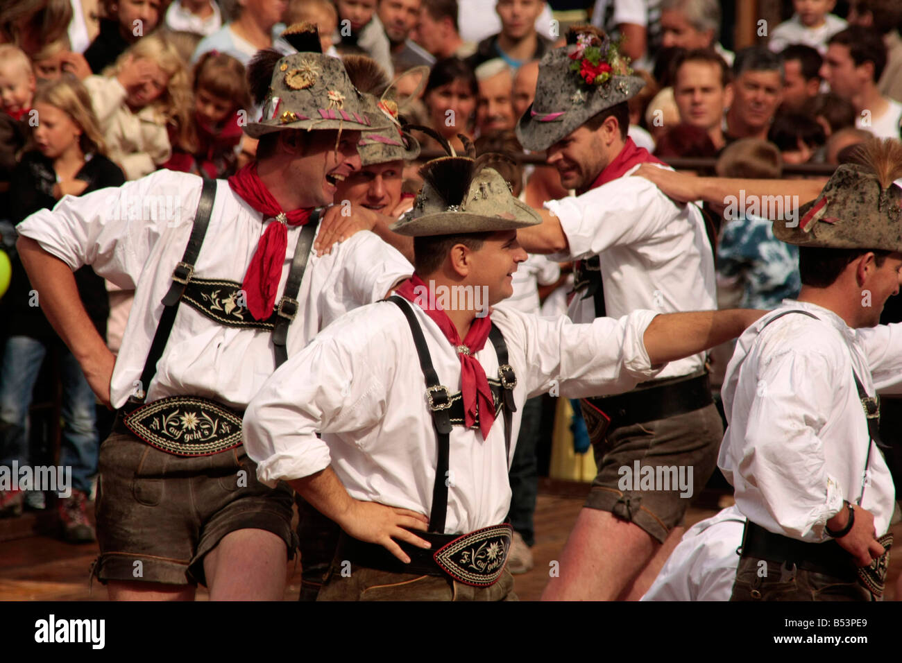young men dancing Schuhplattler in their traditional costumes during ...