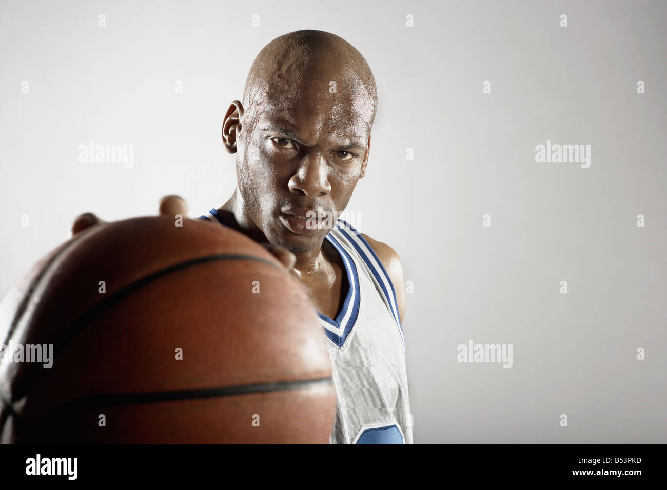 Sweating Hispanic basketball player holding basketball Stock Photo - Alamy