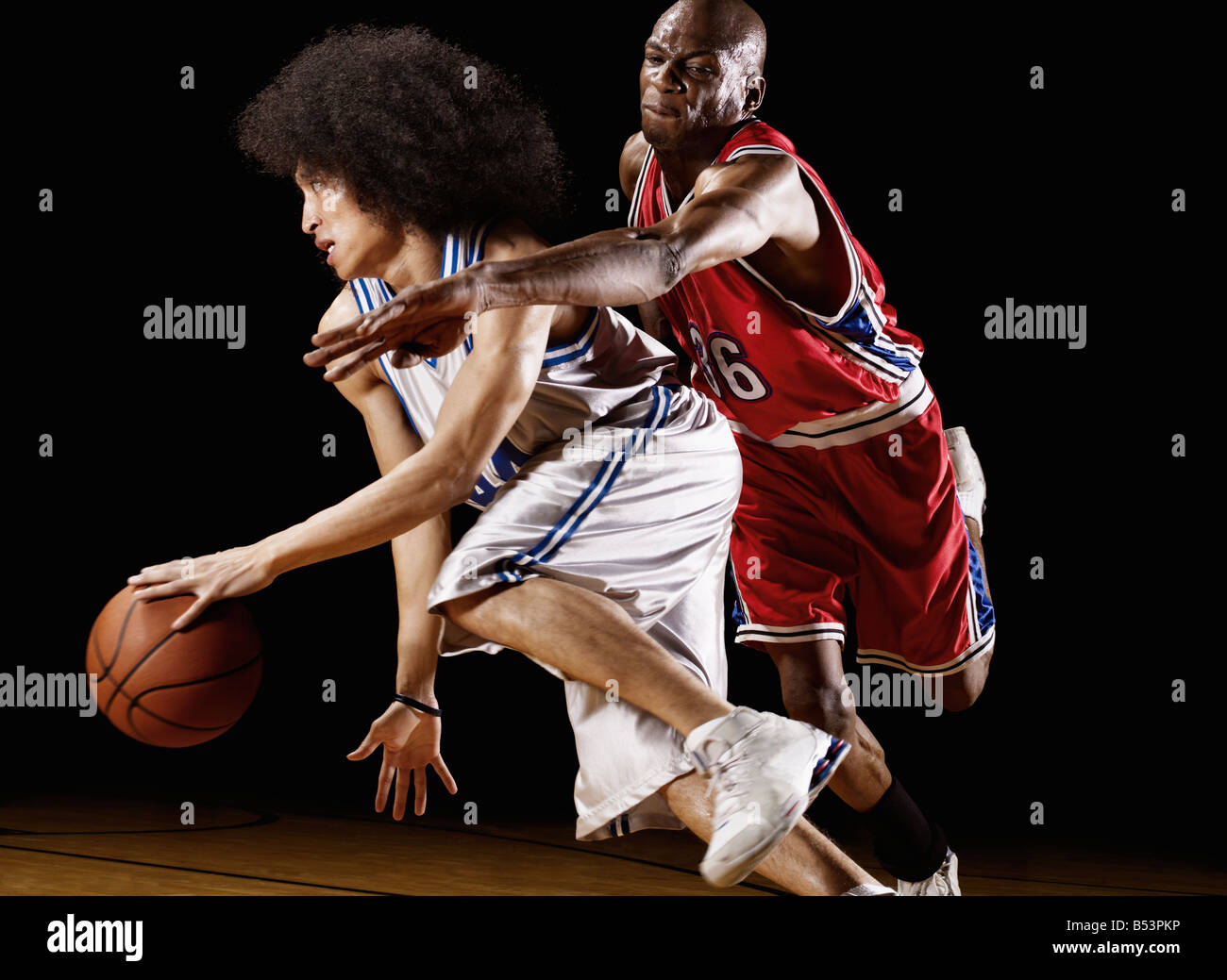 Basketball player trying to take basketball from opponent Stock Photo ...