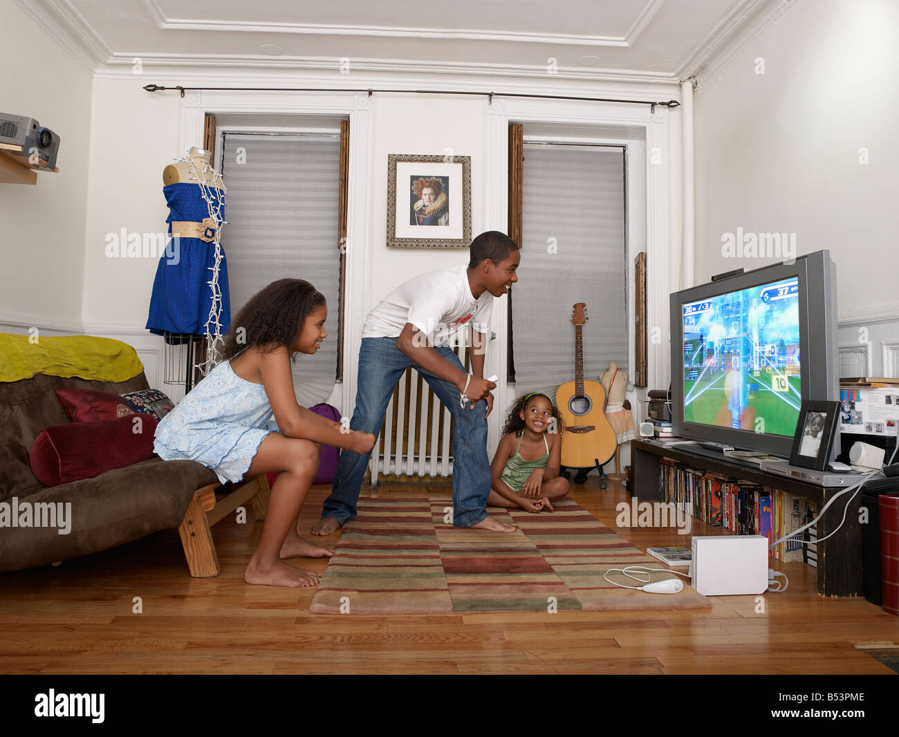 Brother and sister playing video game in living room Stock Photo - Alamy