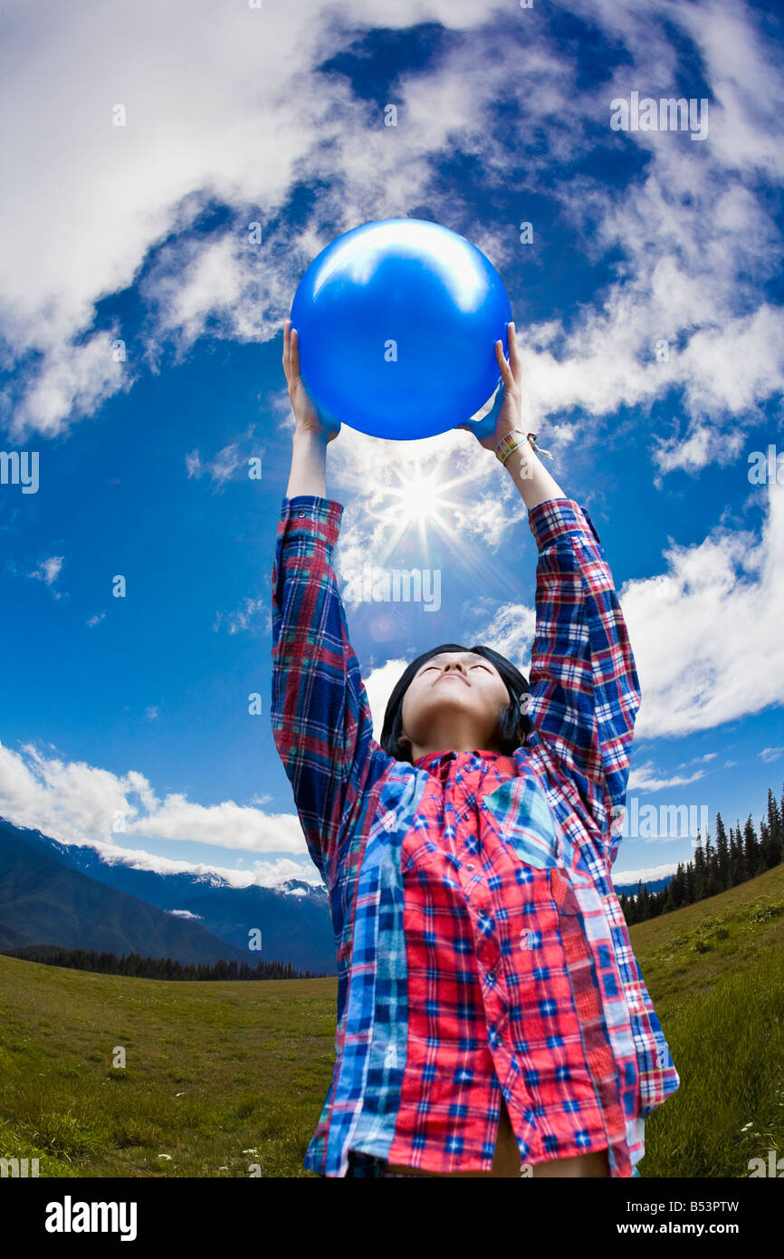 Asian man lifting ball in remote field Stock Photo - Alamy