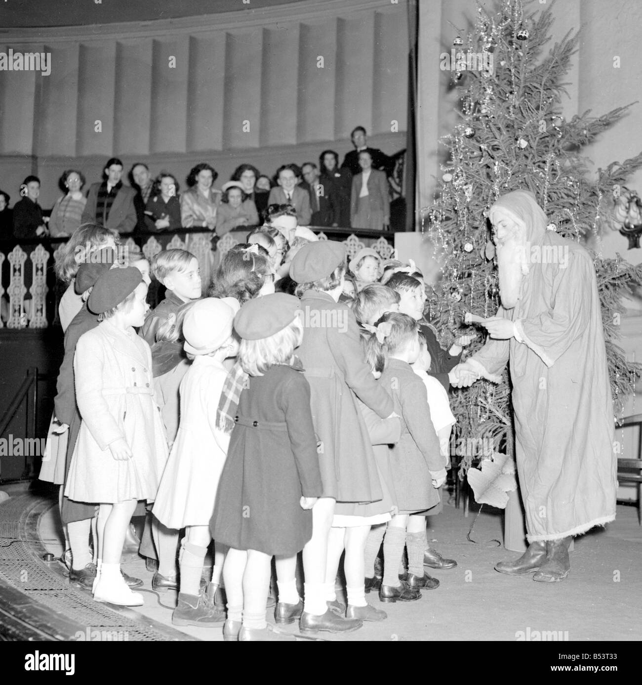A Teddy Boy dressed as Father Christmas hands out presents at the ...