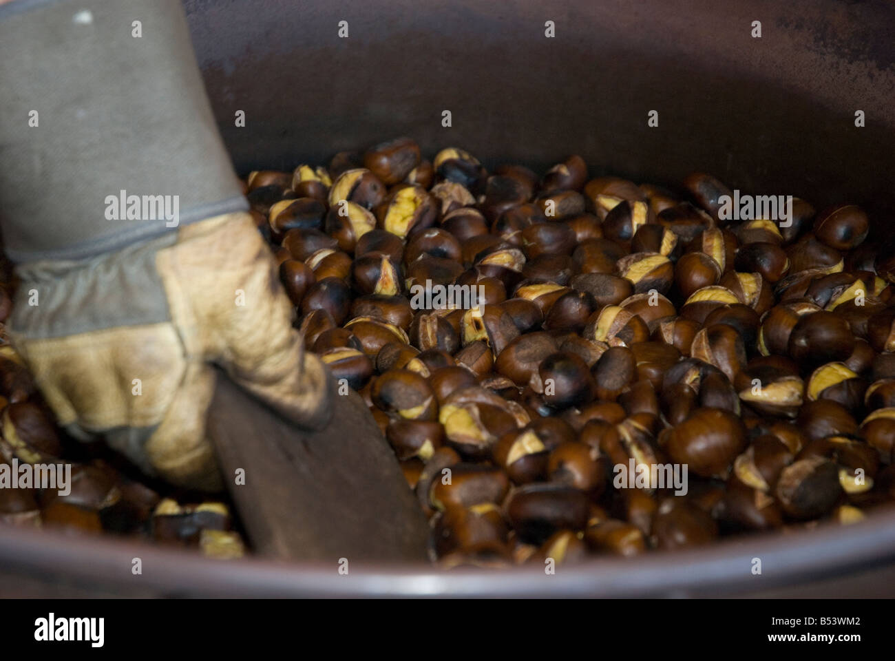 Chestnut vendor stirring chestnuts as they roast Stock Photo - Alamy