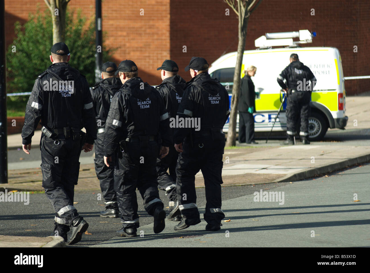 Police search team look for evidence on the street nearby a murder in ...