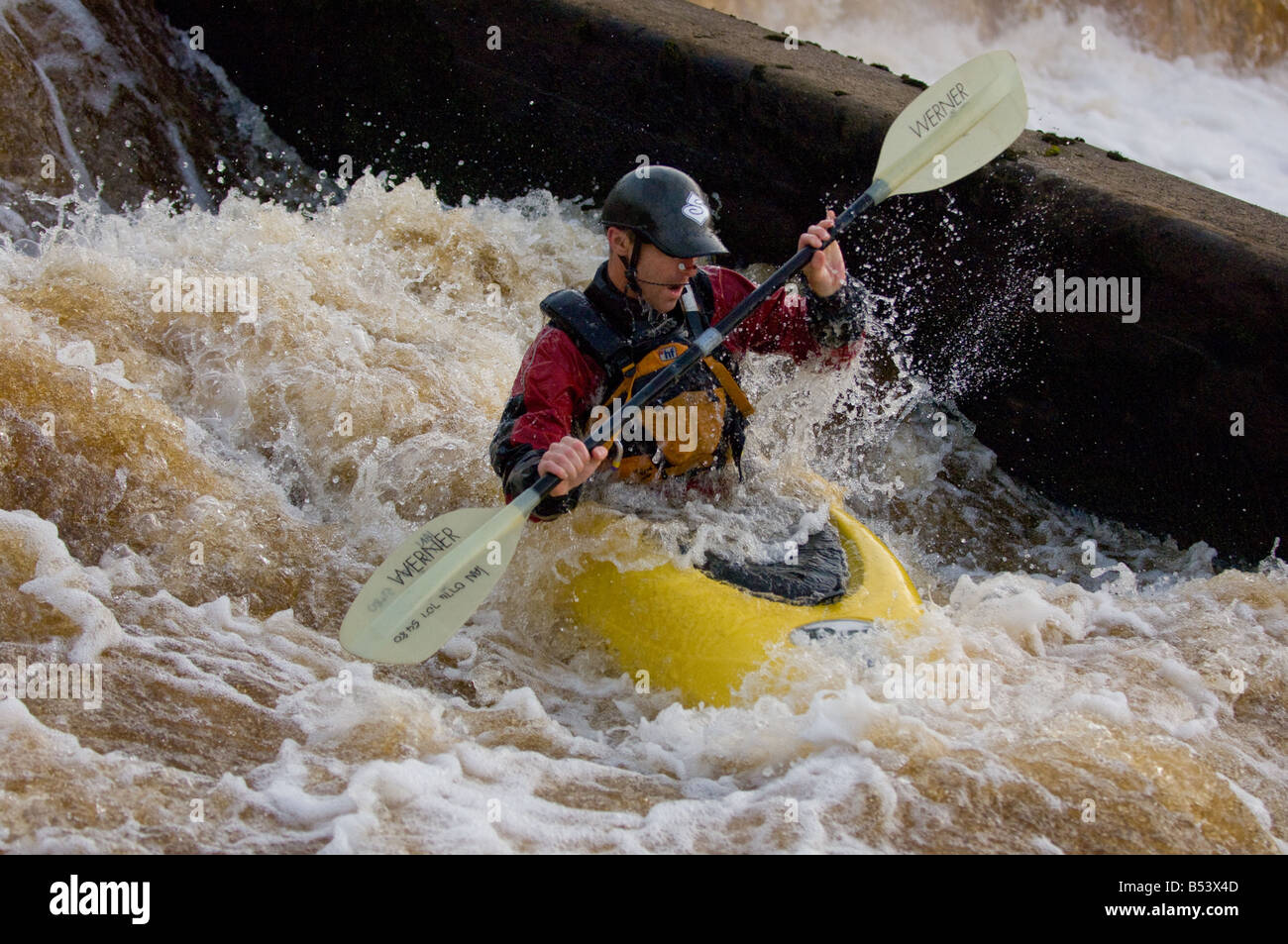 Caucasian male kayaker in a bright yellow kayak in white water on a ...