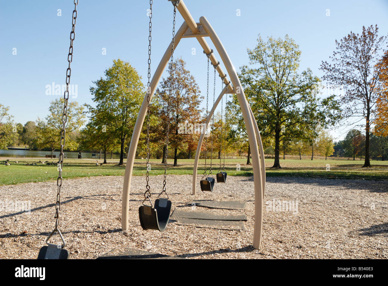 empty swing set on playground in fall Stock Photo - Alamy