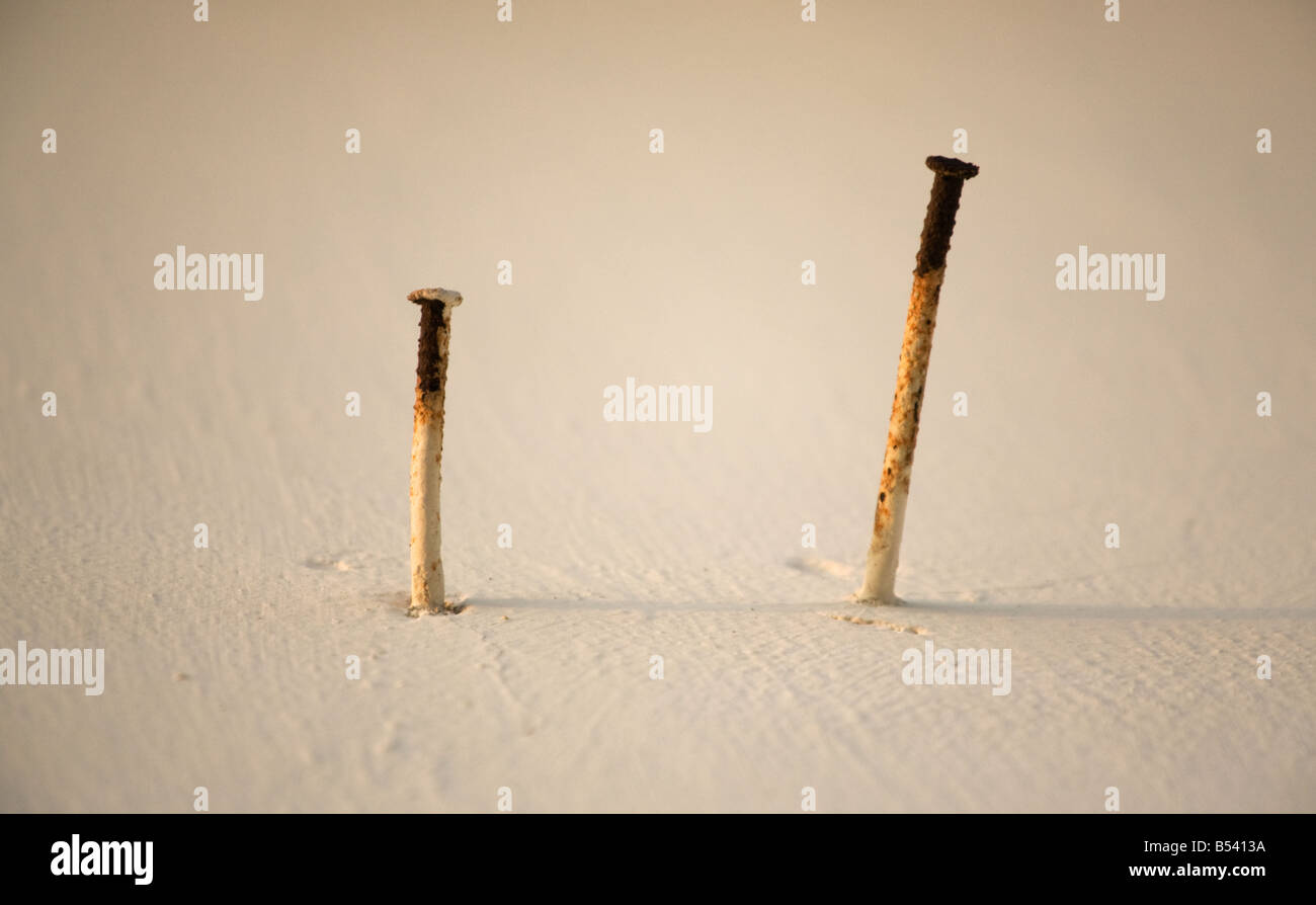 Nails in a white washed wall Stock Photo - Alamy