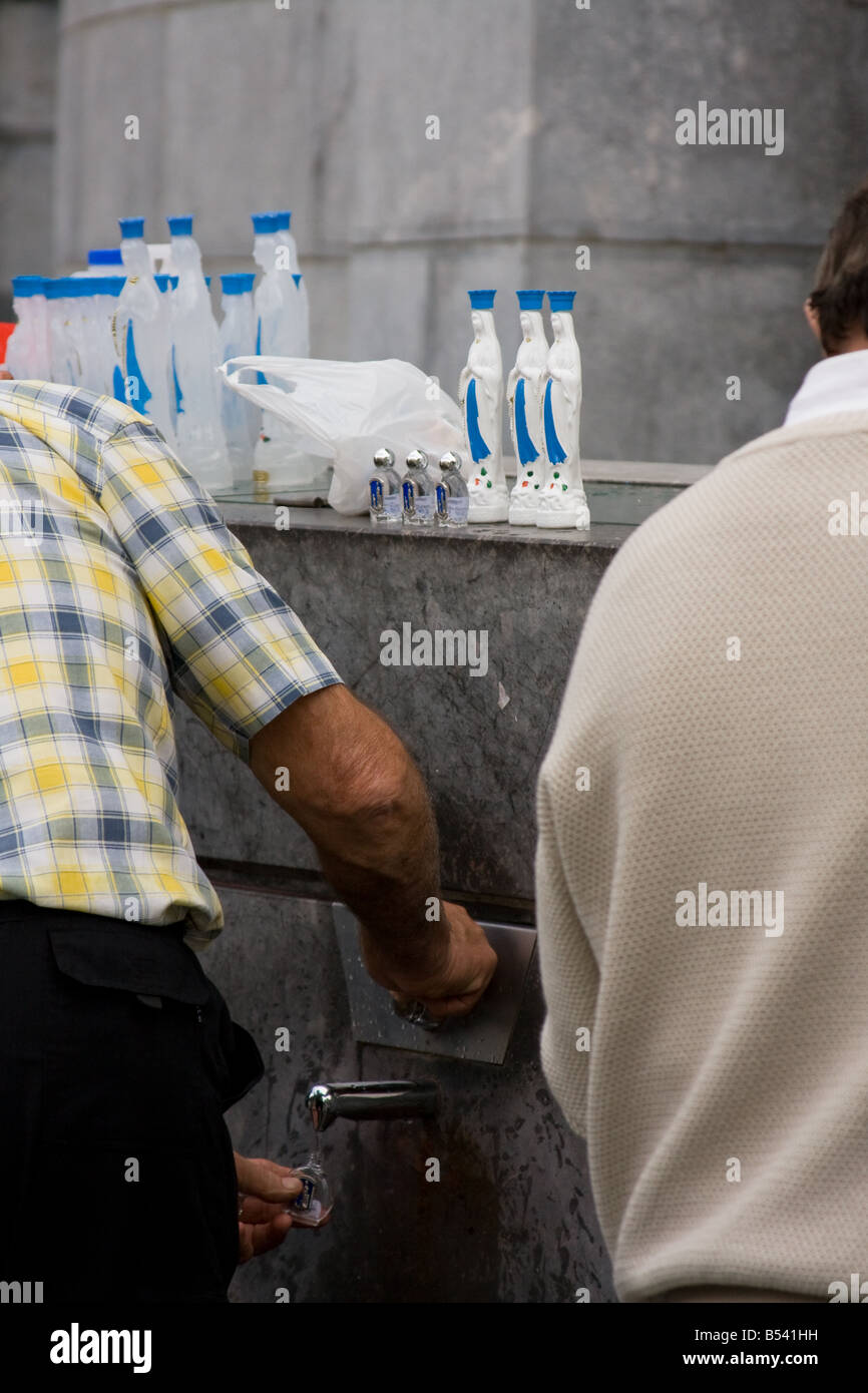 Filling holy water bottles - Lourdes, Southern France Stock Photo - Alamy