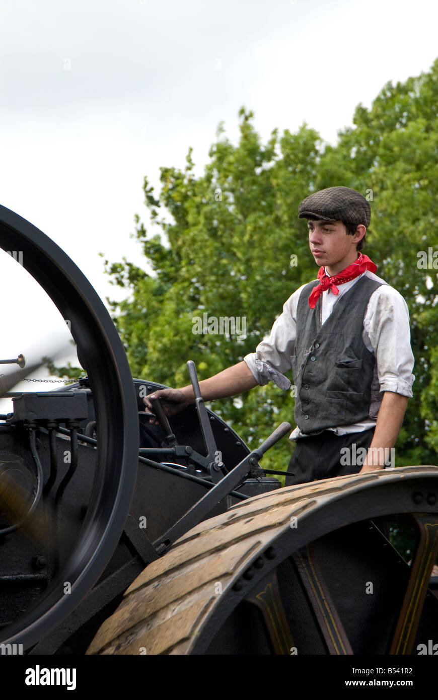 A young enthusiast driver prepares to drive a steam traction engine to ...